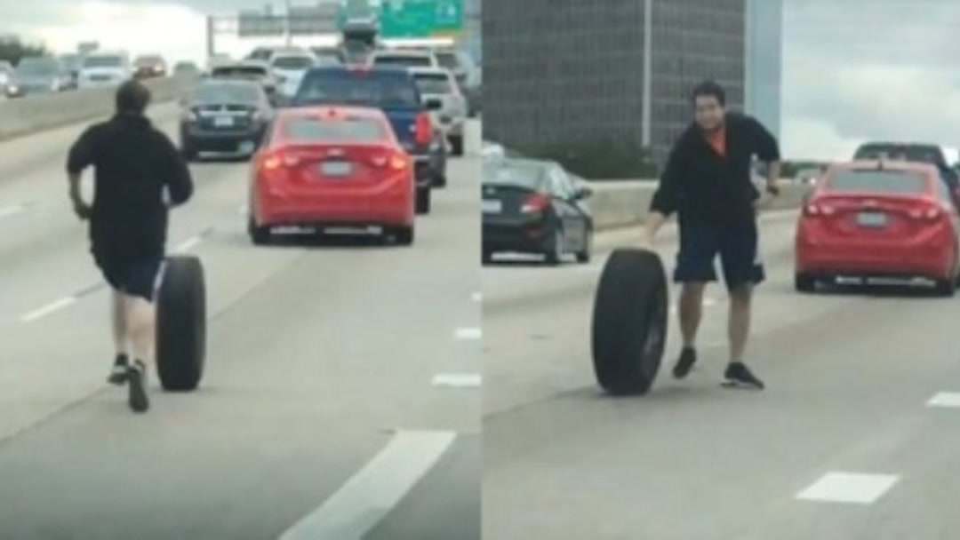 男子公路上追逐滚动轮胎 司机们与其保持距离