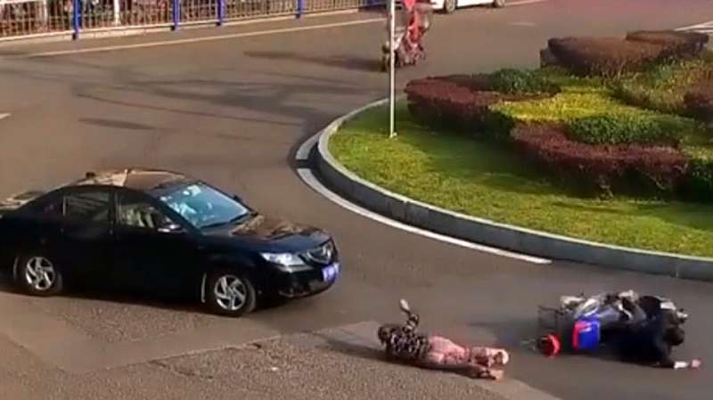 小车与电动车转盘路段相撞2人倒地受伤 监控还原全过程