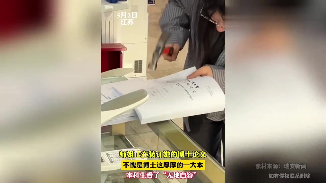 师姐正在装订她的博士论文,不愧是博士这厚厚的一大本