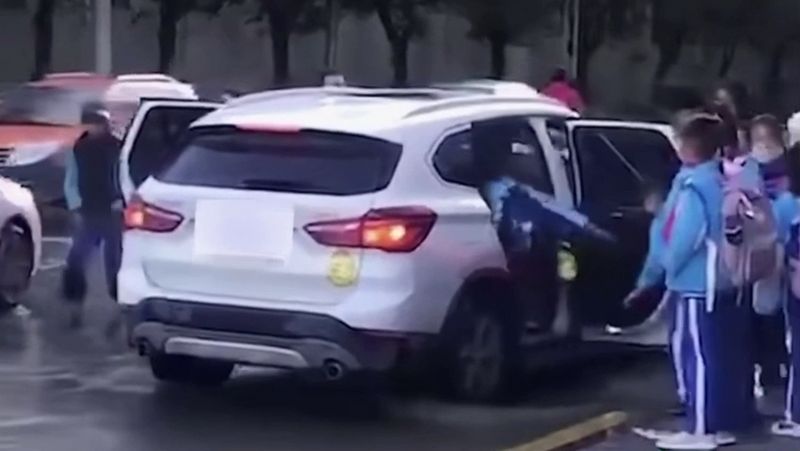 雨后路边积水过深,男子用自己的汽车为小学生搭起了一座桥!