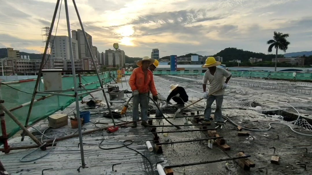 老乡在桥面上施工。用震动棒震混泥土。工作挺辛苦。