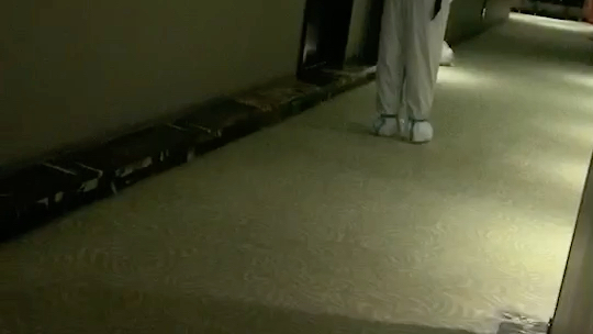 酒店隔离中工作人员认真的消毒走道