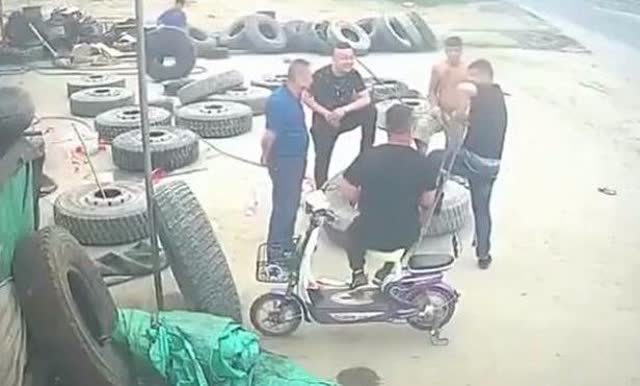 几名男子站在门口聊天,下一秒轮胎突然爆炸,监控拍下惊险瞬间
