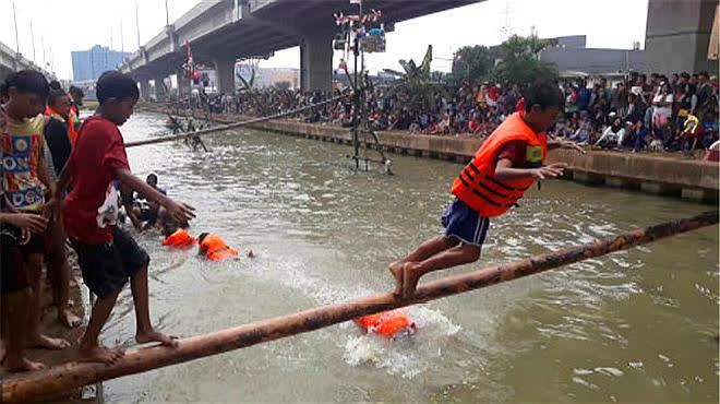 印度独木桥比赛,村长将"润滑油"倒在木棍上,游客们纷纷中招!