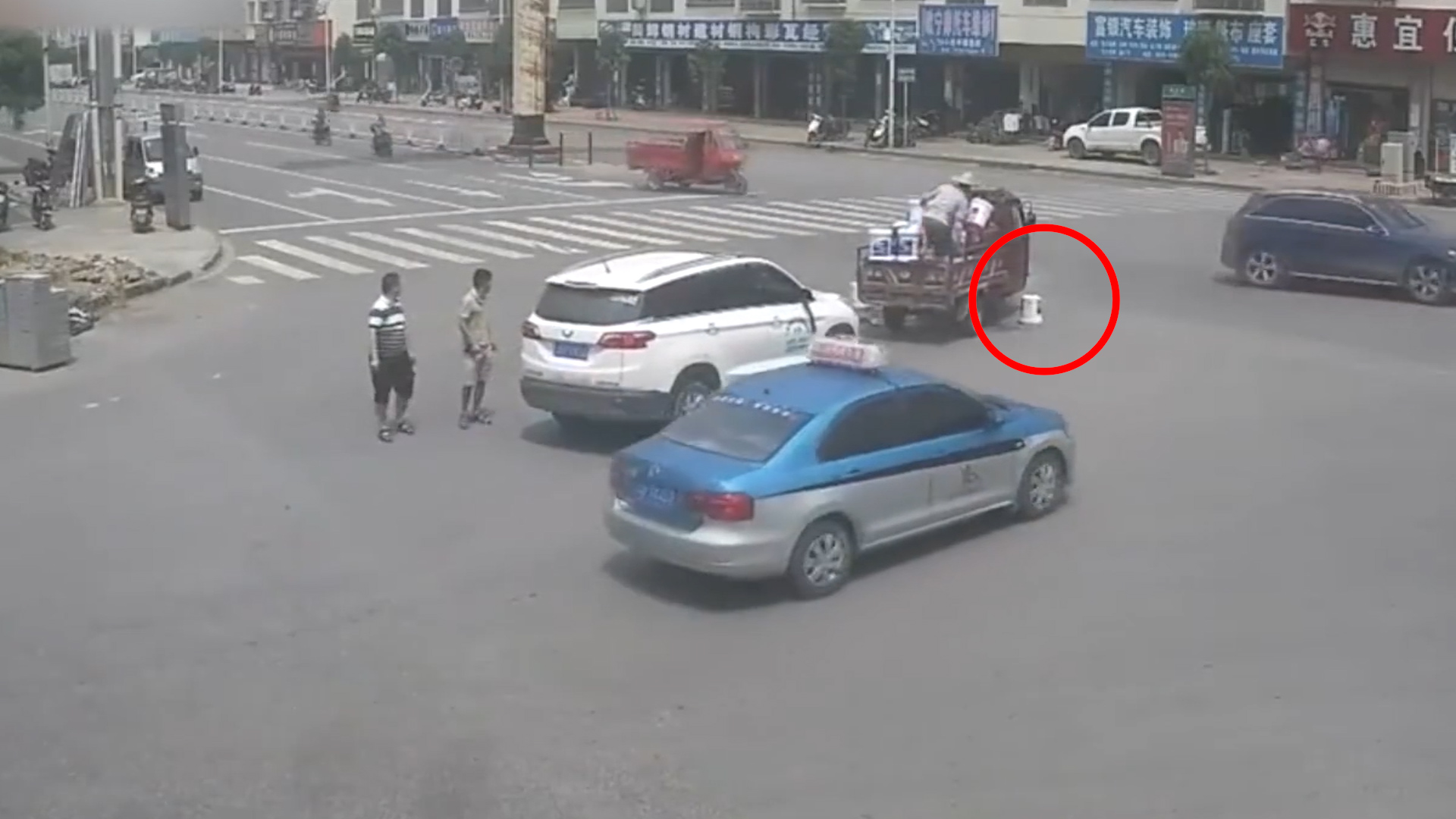 三轮车在路口洒落润滑油,前后有9辆电动车摔倒