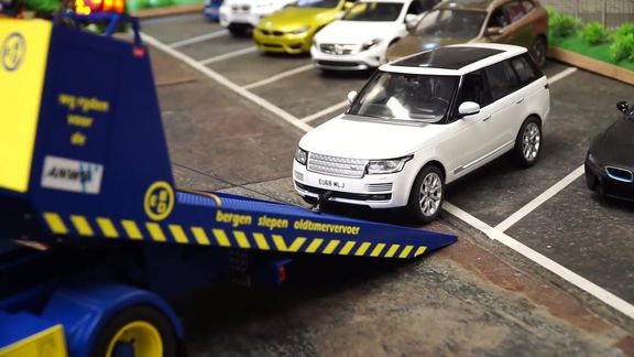 停车位上的这辆SUV,要被拖车拖走了,仿真模型车做的像不像?