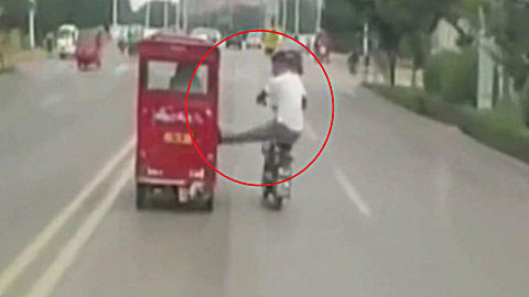 电动车小伙脚踹三轮车,自己反而翻车了,没事你乱踢啥