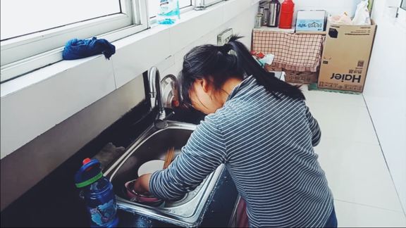 小学生放假在家帮妈妈做一些力所能及的小家务。