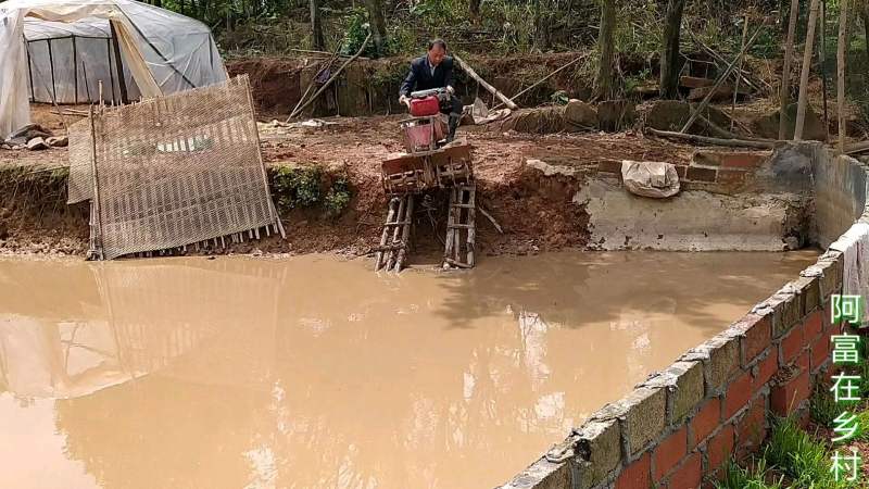 阿富开微耕机打水田,他用几根木棍搭桥开微耕下田的方式有点危险