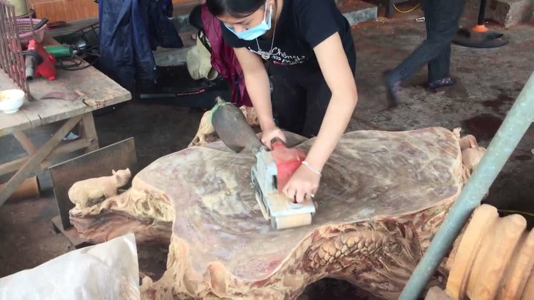 女木工师傅瓶抛光打磨一块大木头 制作成桌子