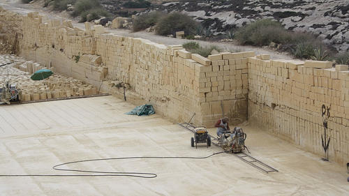 开采石材全过程,切割机来回不停走动,一块块石料就切下来了