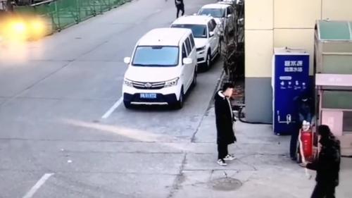 三位小伙在研究灭火器。不知道正确使用方法,结果自己被喷了