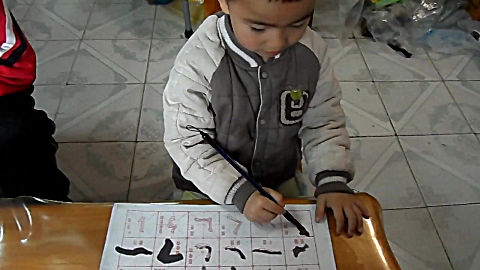 爷孙俩练习写毛笔字,宝宝拿毛笔手势错了,字写成那样