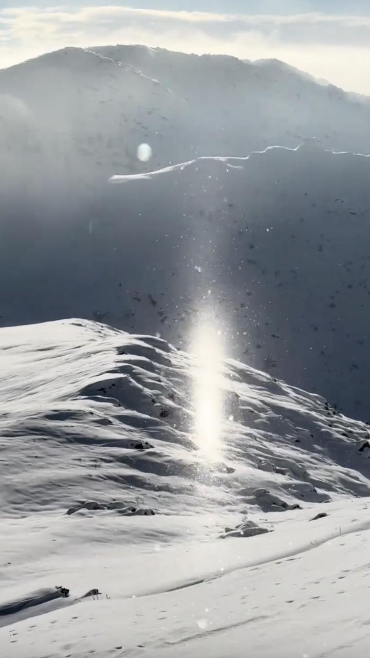 1月17日,新疆阿勒泰。男子在山上滑雪时偶遇神奇光束,通体发亮神似"...