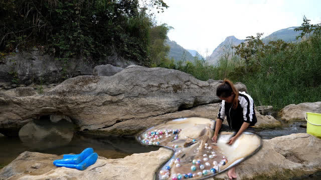 深山水潭里竟捞出巨型珍珠蚌,美女好奇打开,高兴的合不拢嘴