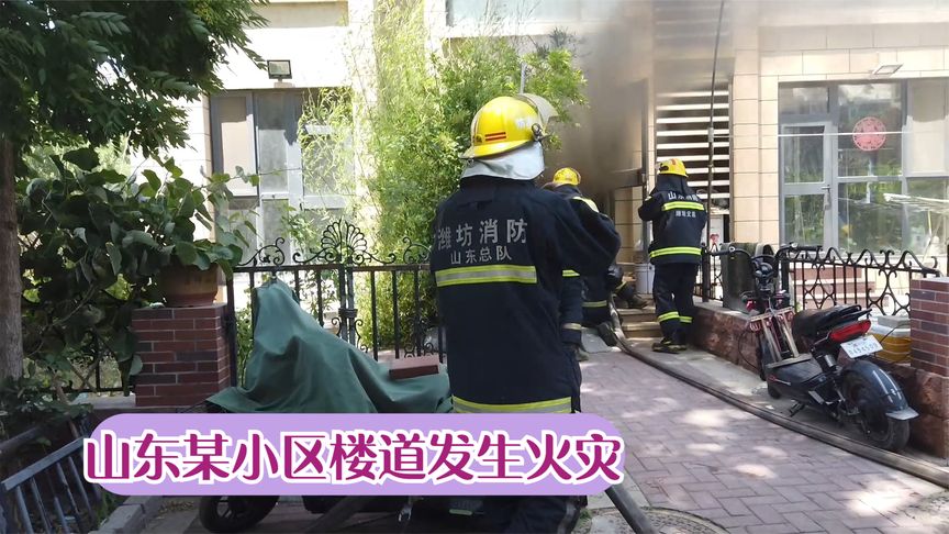 山东某小区楼道突然失火严重 消防员迅速赶到失火现场救助群众