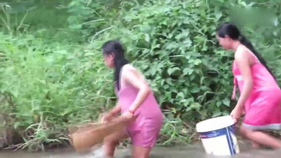 为了抓到大鱼 这两位漂亮的农家美女用簸箕每天在抓鱼 很是辛苦