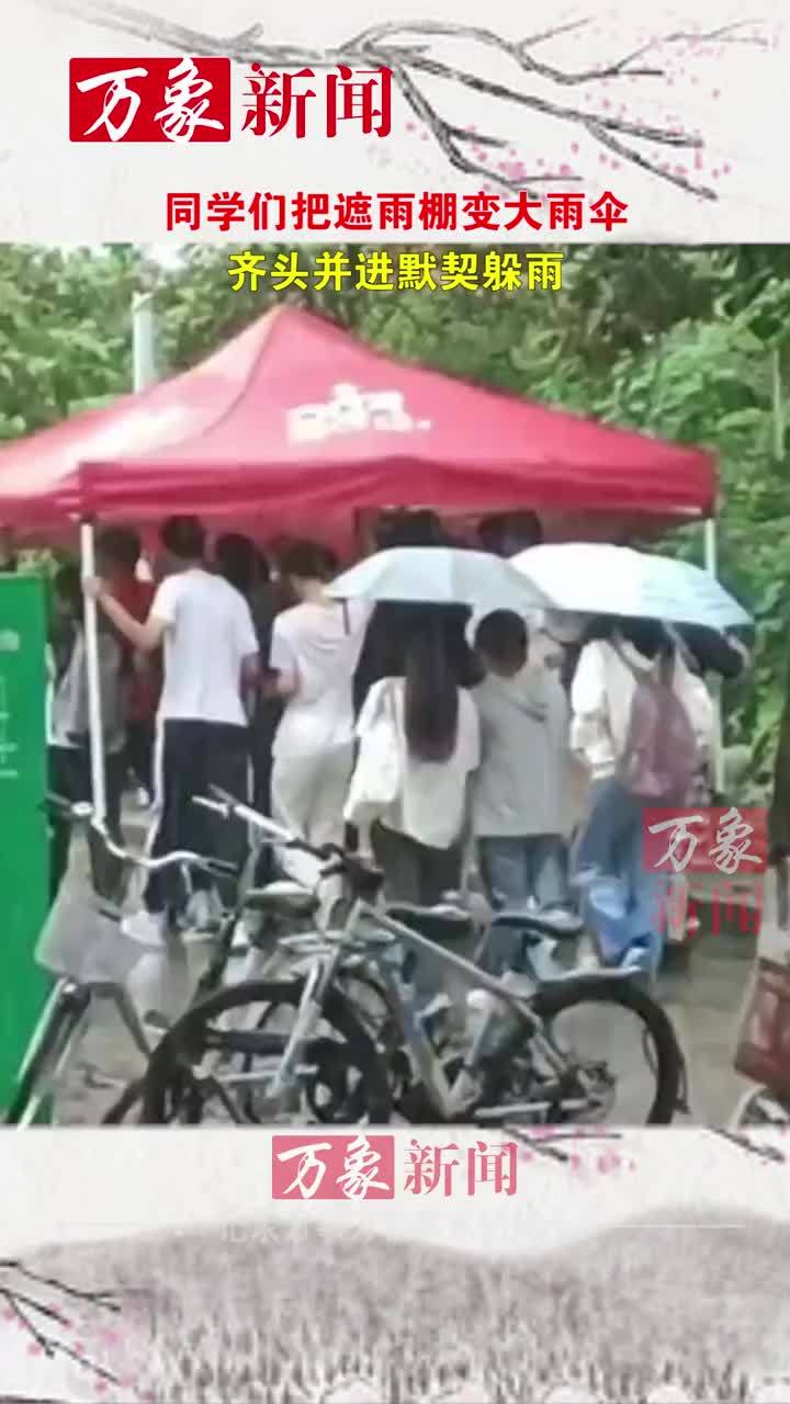 同学们把遮雨棚变大雨伞,齐头并进默契躲雨#现场直击 #新闻 #学校
