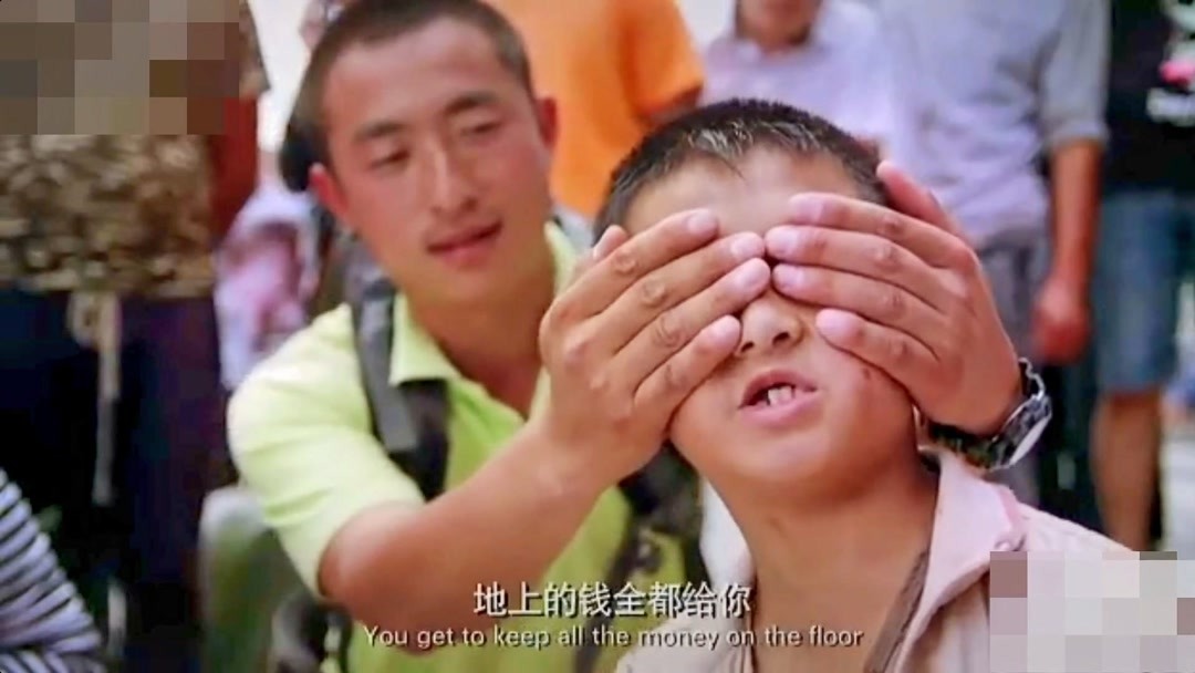 小男孩是瞎子,被人贩子拐走了,在大街上乞讨,好心人搭救却不敢