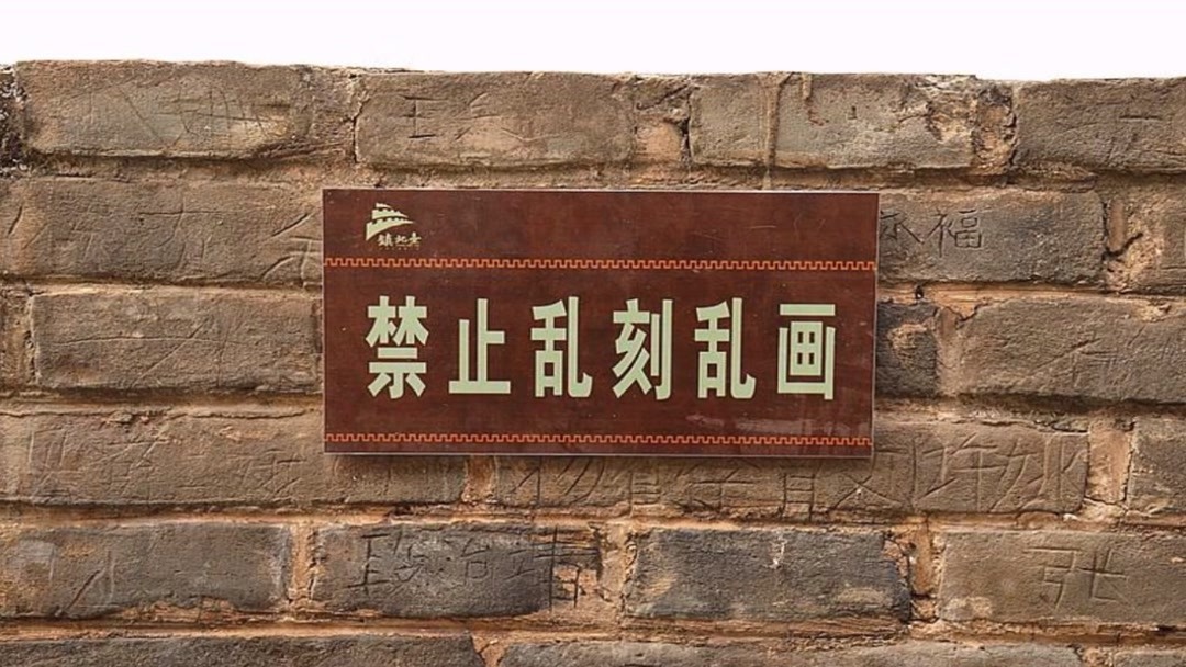 3名游客在八达岭长城刻字