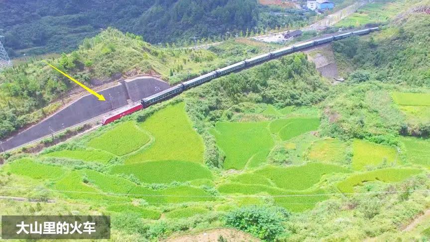 绿皮火车缓缓经过贵州大山,形成大山里一道亮丽的景色