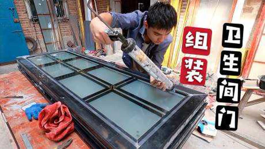 小伙先组装好卫生间门,再跟运去安装,黑色跟红色哪款更好看