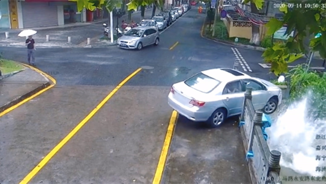 轿车因操作不当冲出桥护栏 半截车身悬空右前轮还在滚动