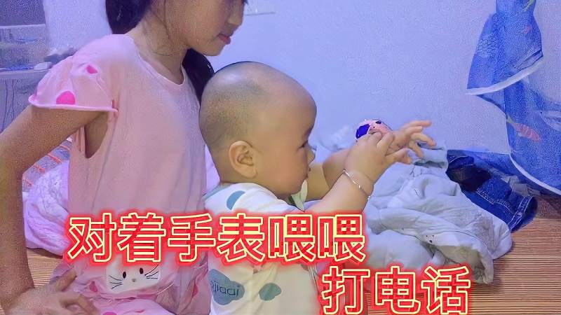 十个月的宝宝拿着手表就往手腕上戴,对着手表就“喂喂”打电话
