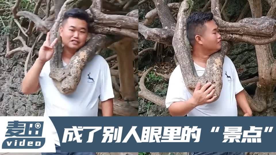 景区内男子脑袋被卡树杈,强忍尴尬假装拍照,一个手势心酸又搞笑