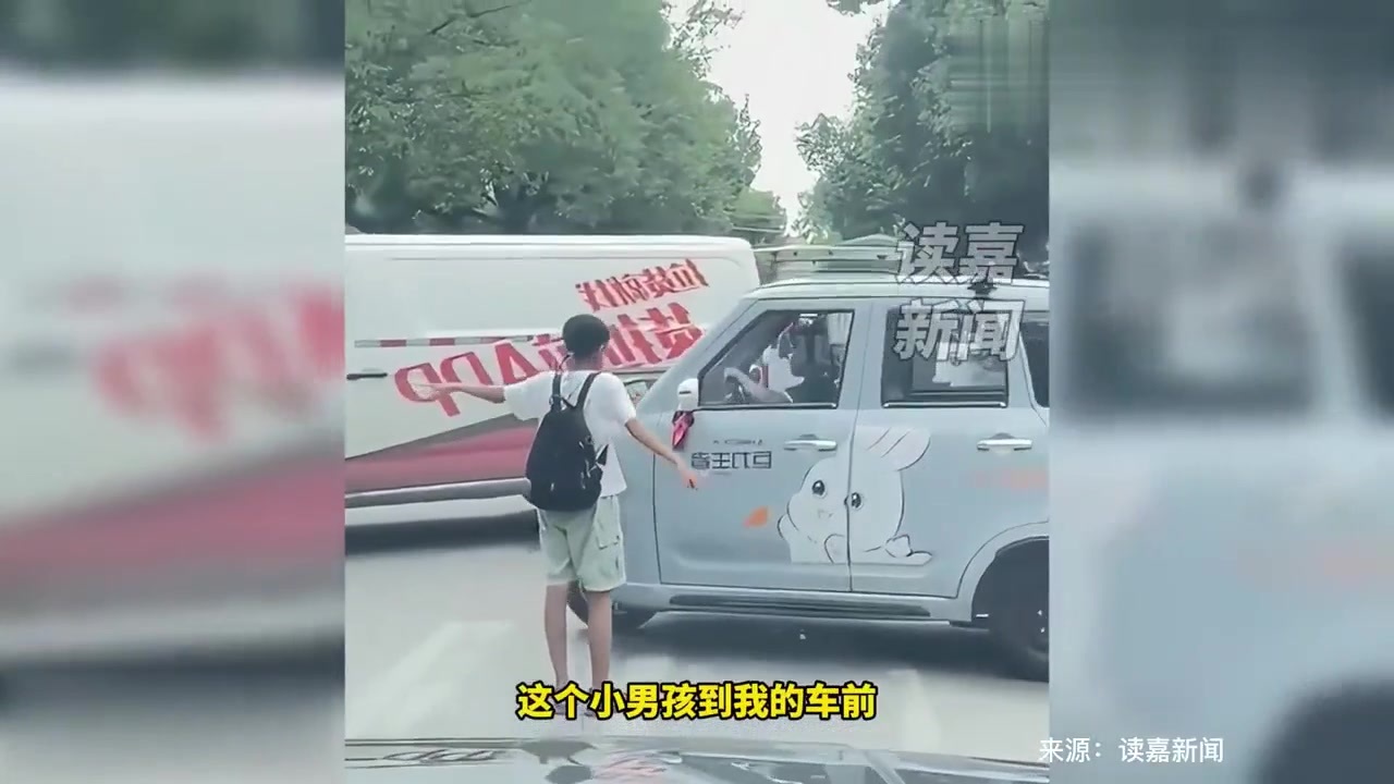 交通堵塞小男孩淡定在路上指挥交通,手势很专业车辆都有配合