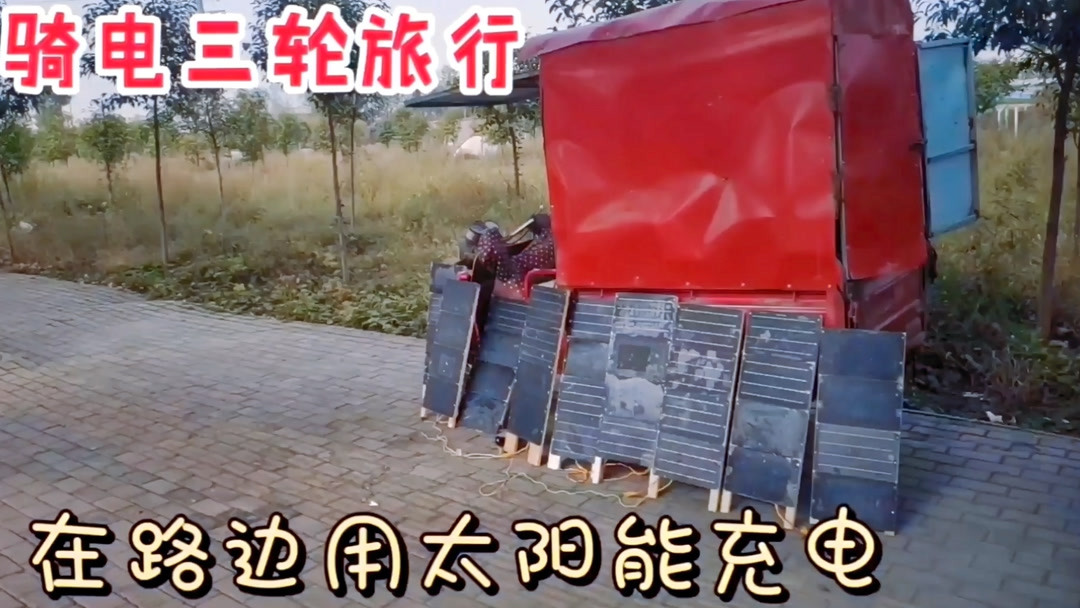 一个人骑电动三轮旅行,停在路边用太阳能充电,引路人围观