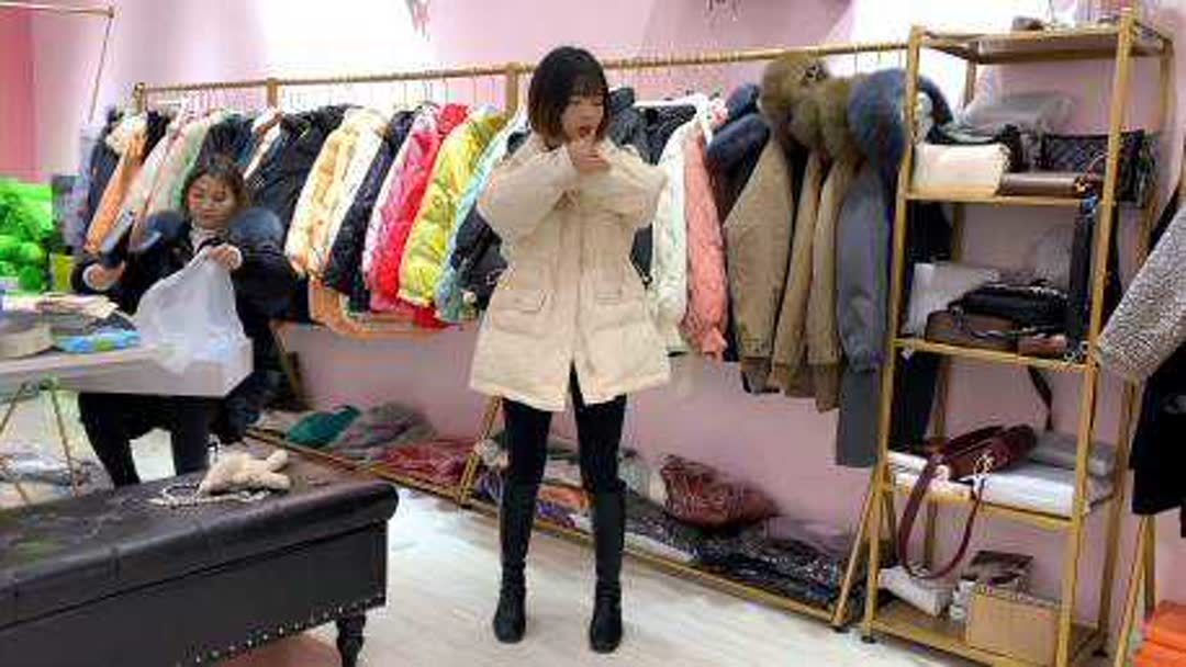 女店主试穿了一款新面料的羽绒服,还配了一个小公仔,效果如何?
