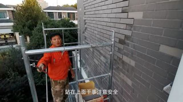 站10米高空贴外墙砖,瓦工用铁丝加固脚手架,老板叮嘱安全第一