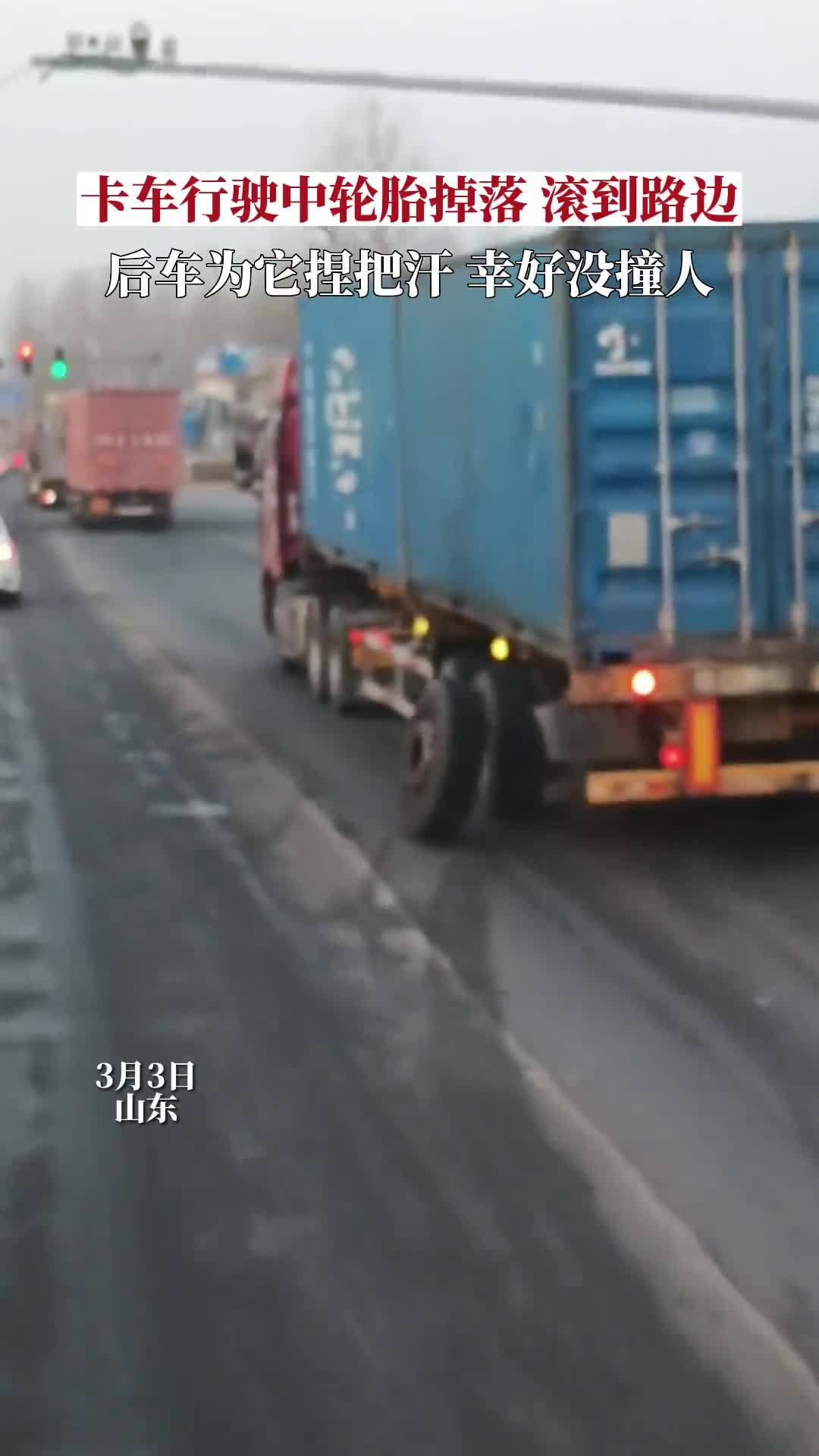 卡车行驶途中轮胎突然掉落,一直滚动到路边,后车为它捏把汗。