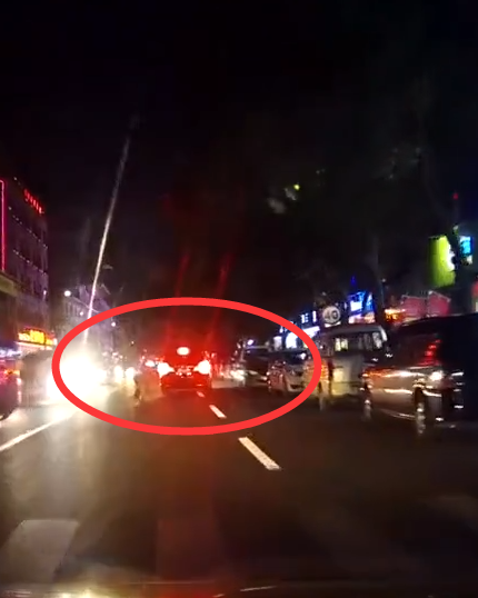 自行车突然冒出撞上轿车后,连自行车都不要了,赶紧溜了