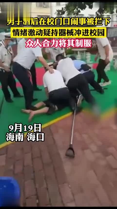 9月19日,海南海口,男子酒后在校门口闹事被拦下,情绪激动疑持器械冲...