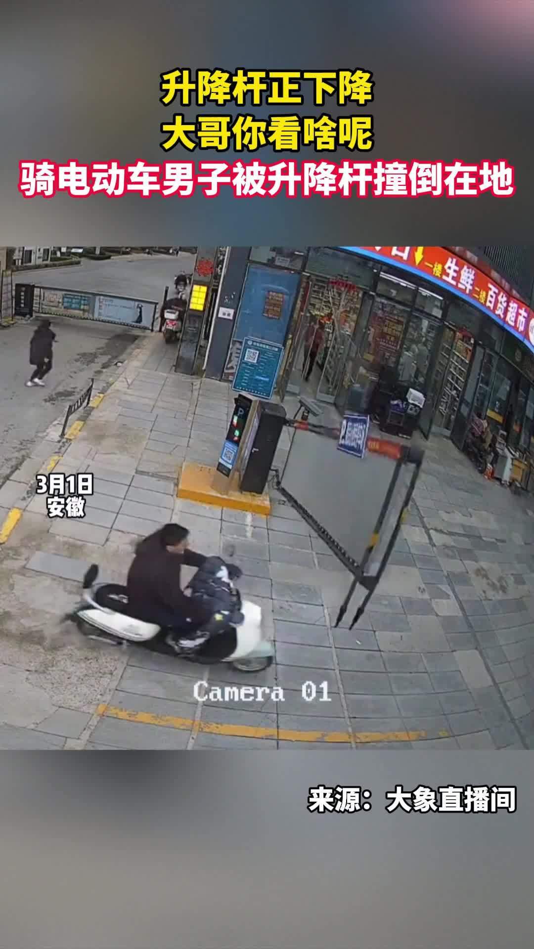 升降杆正下降,大哥你看啥呢!骑电动车男子被升降杆撞倒在地
