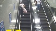 夫妻俩在扶梯不慎被行李绊倒,保洁阿姨摔倒后忍痛狂奔救扶