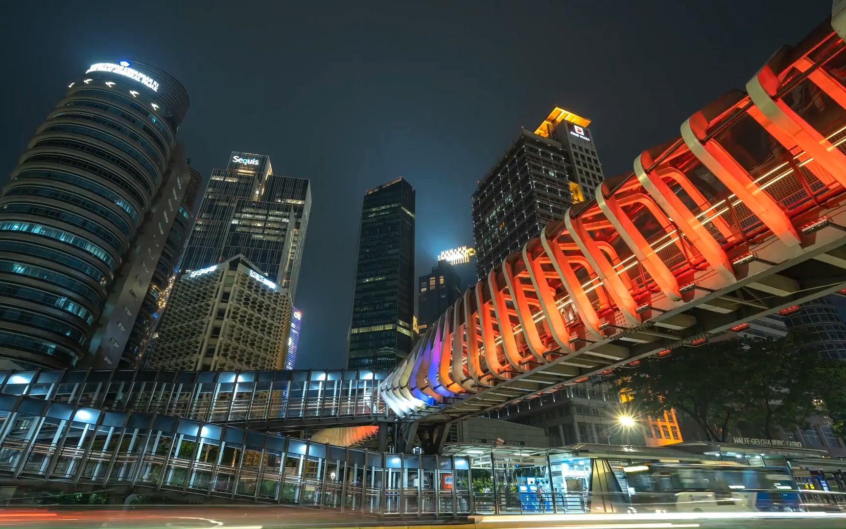 雅加达,印度尼西亚-时间拉佩现代城市景观建筑多彩的桥梁夜晚人们苏...