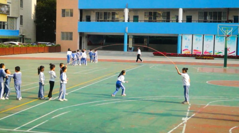 实拍小学生操场体育课场景,男女学生在跳绳,有趣快乐
