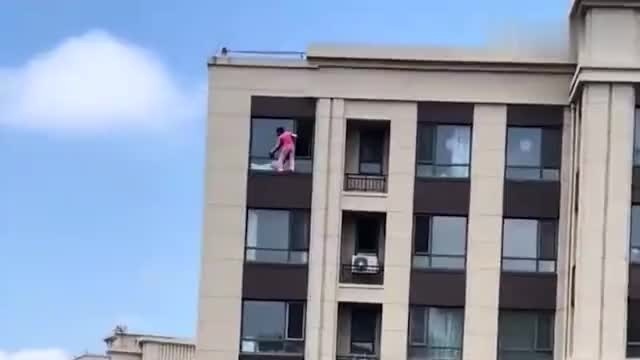 女子站在30多层高楼外徒手擦玻璃,男子拍下惊险一幕:擦10多分钟