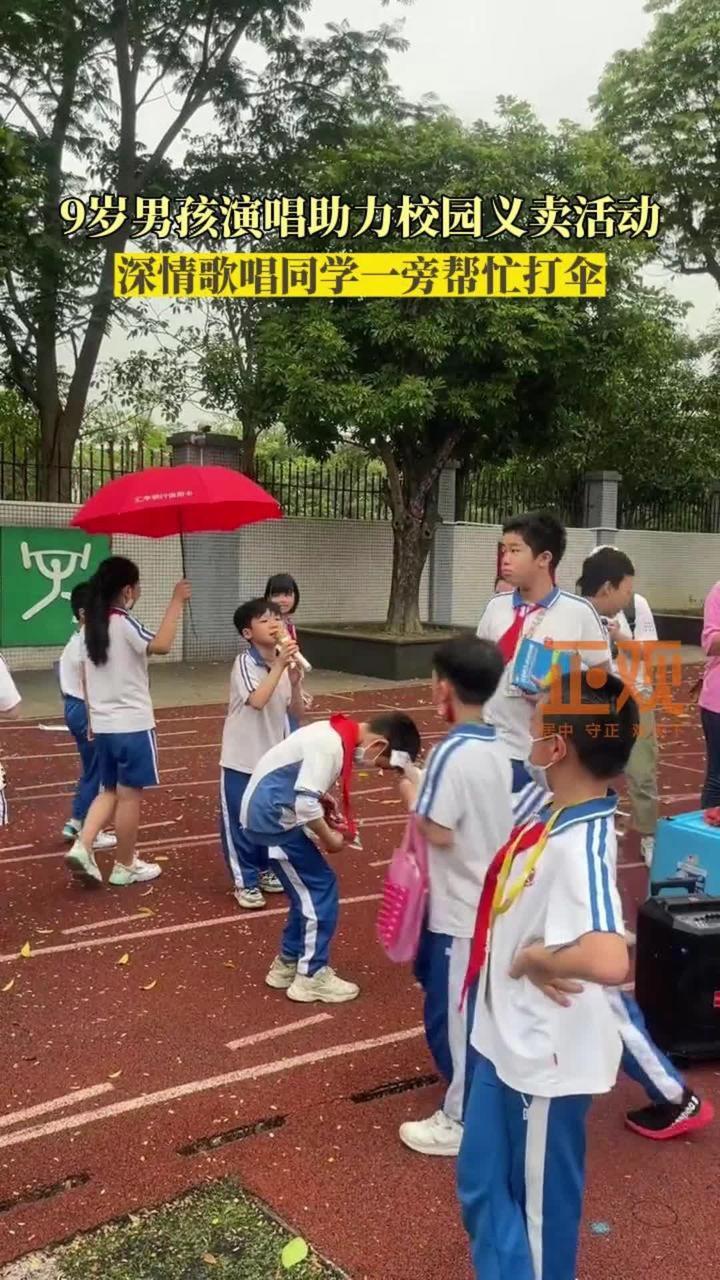 21日#广东广州 9岁男孩演唱助力校园义卖活动,深情歌唱同学一旁帮忙...