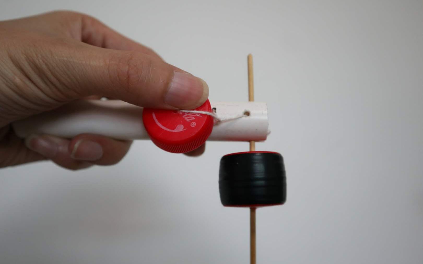 瓶盖制成的小陀螺,细绳一拉就能旋转,转的时间还蛮长