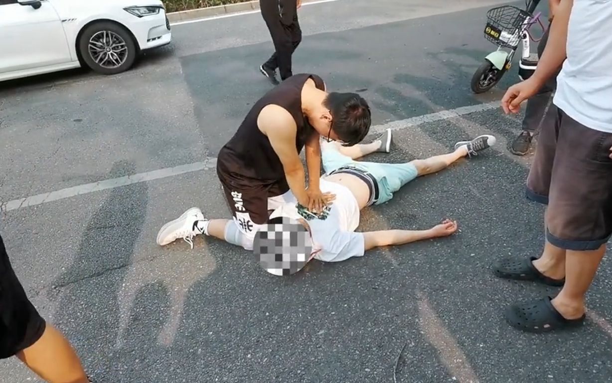 好心小伙跪地对车祸伤员进行急救,直到医生到场才默默离开