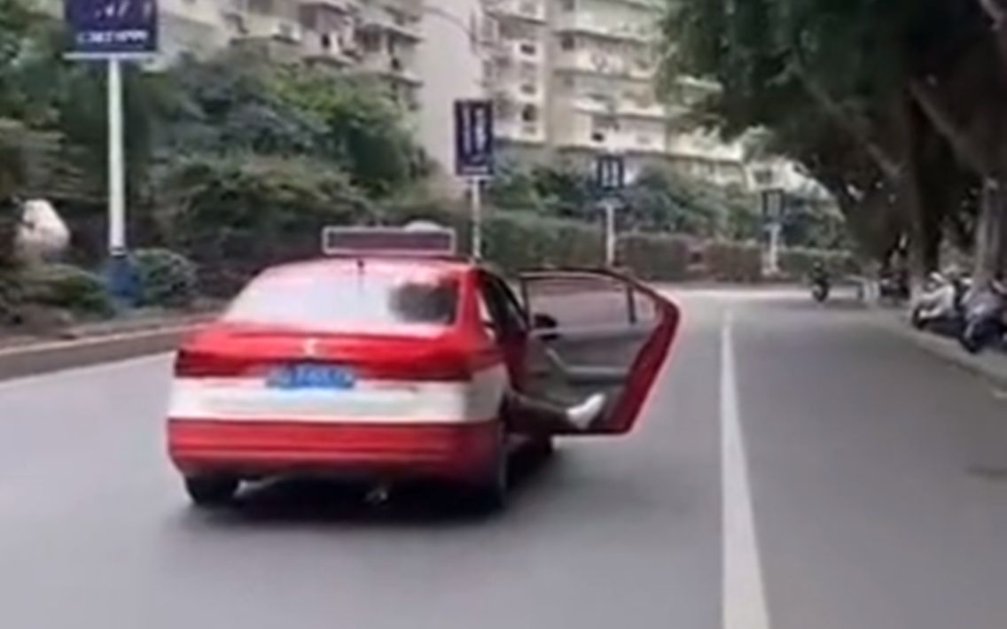 因开车路线与出租车司机产生纠纷 行驶过程中女乘客用脚撑开车门