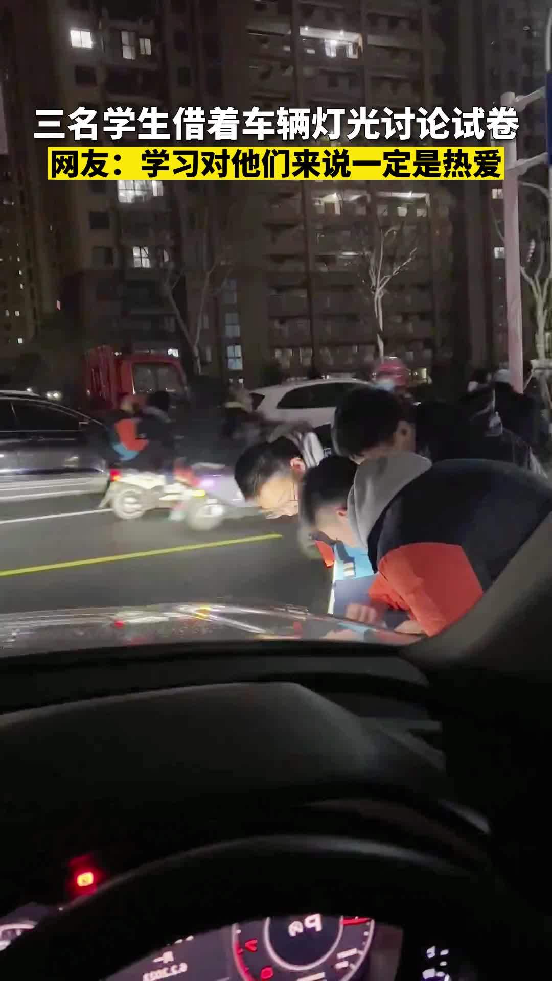 三名学生借着车辆灯光讨论试卷
