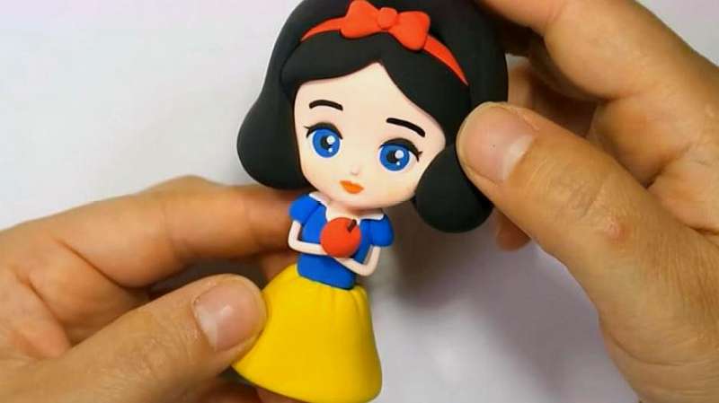 手工师用橡皮泥做了个白雪公主,还给她捏了个苹果