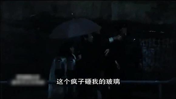 一个女人在下雨的夜晚拿石头砸人玻璃被警察追