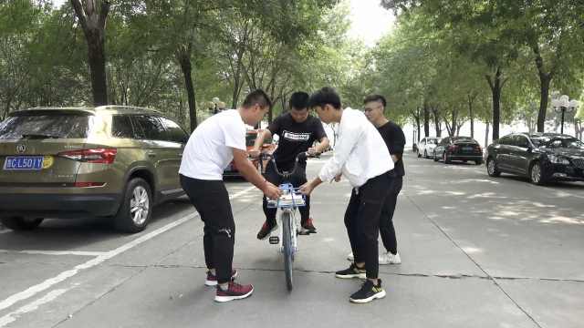 暖心!新生学骑自行车,室友手把手教