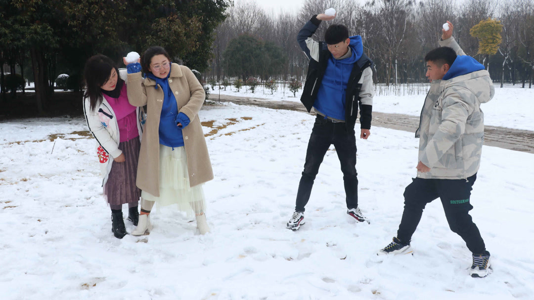 下雪了!老师带同学们在雪地里打雪仗,老师和学生之间的快乐互动